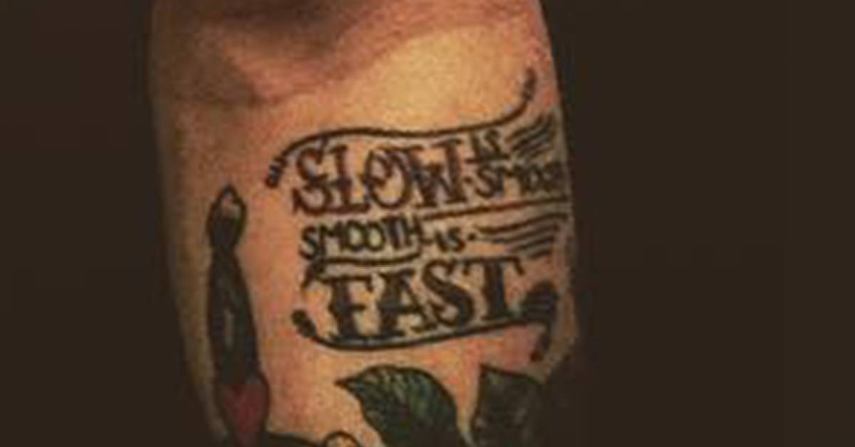 "Slow is smooth, smooth is fast" tattoo on the left