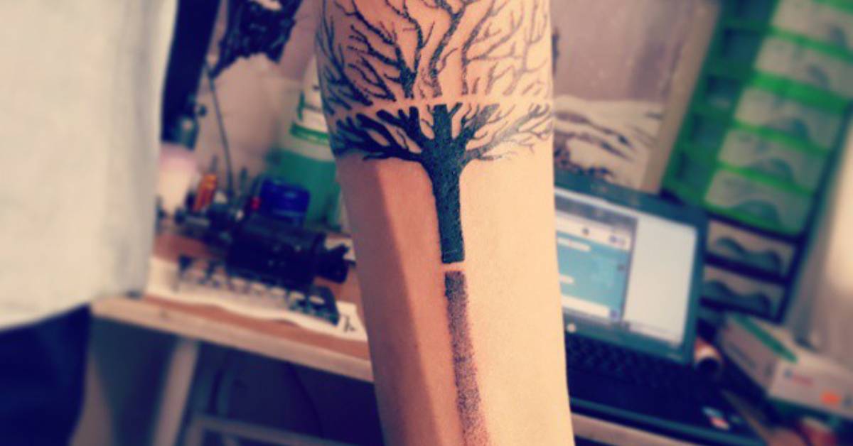 Forearm tattoo of a tree and two lines on Martin.