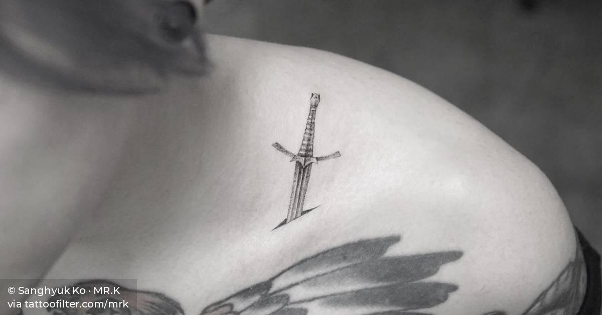Stabbed sword tattoo on the top of the left shoulder.