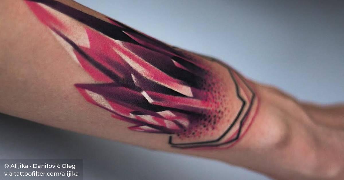 Red gem tattoo on the right forearm.
