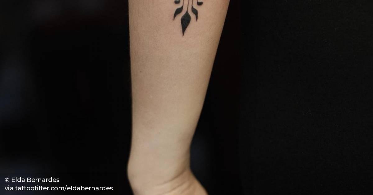 Ornamental armband tattoo on the left forearm.