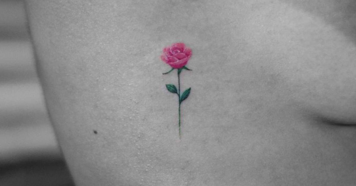 Tiny pink rose tattoo on the right ribcage.