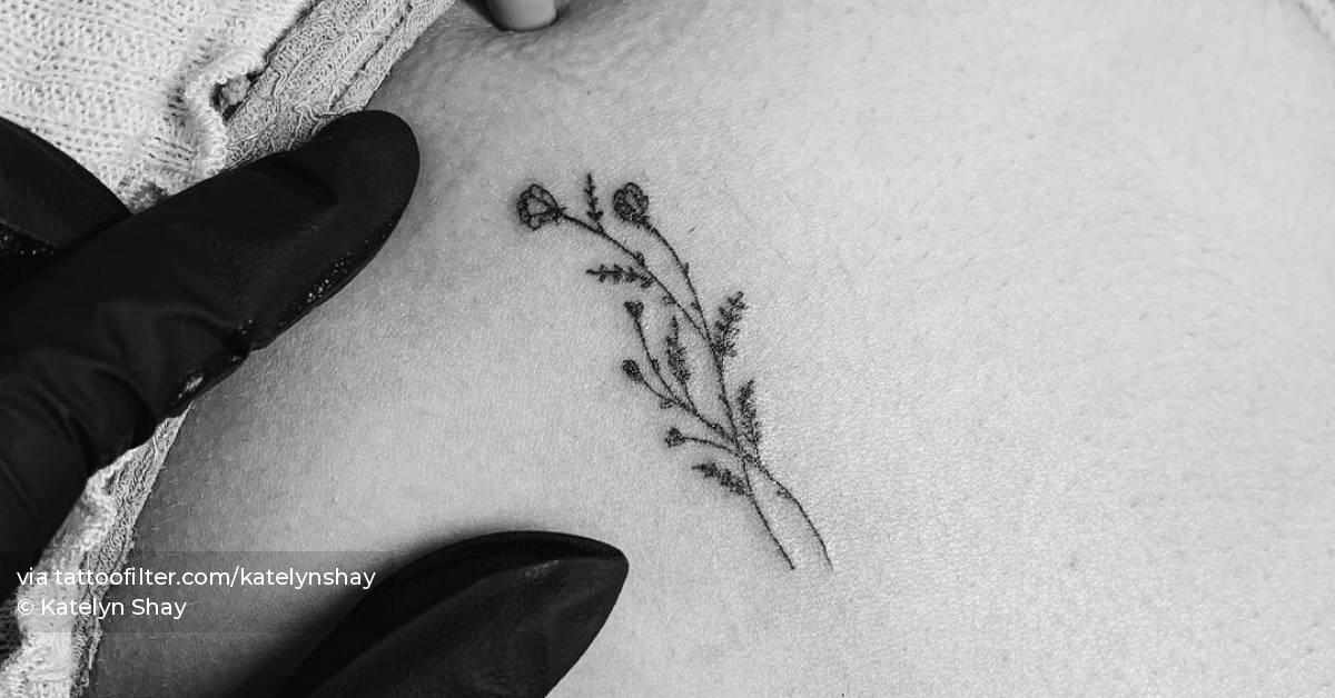 Tiny flower tattoo on rib