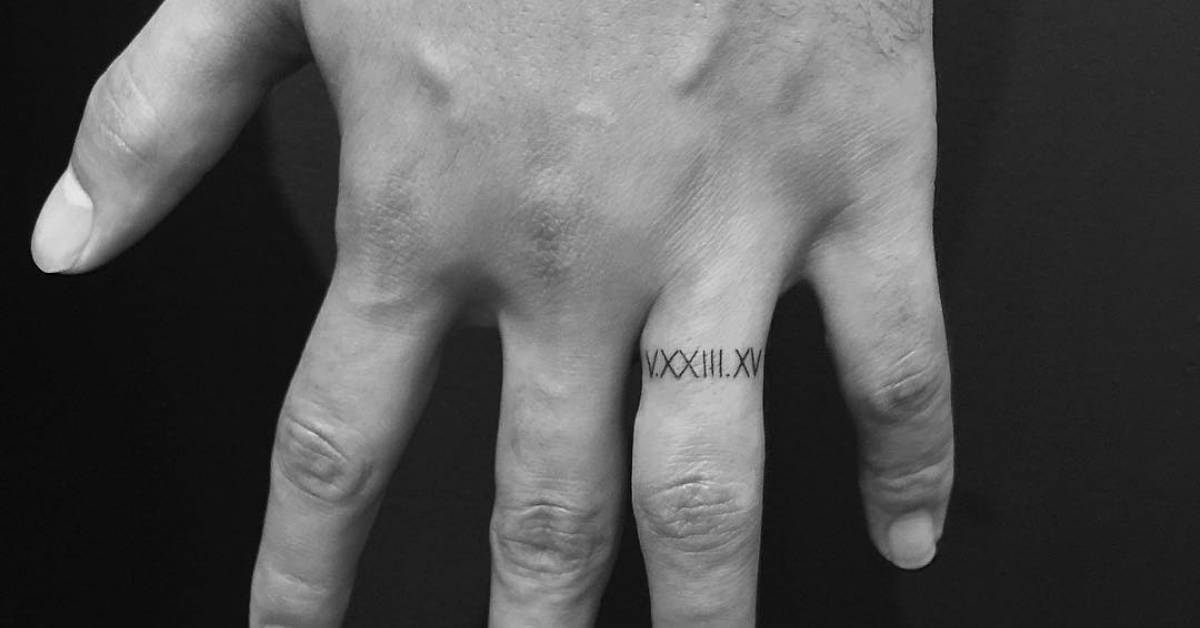 Marriage date tattoo on the left ring finger.