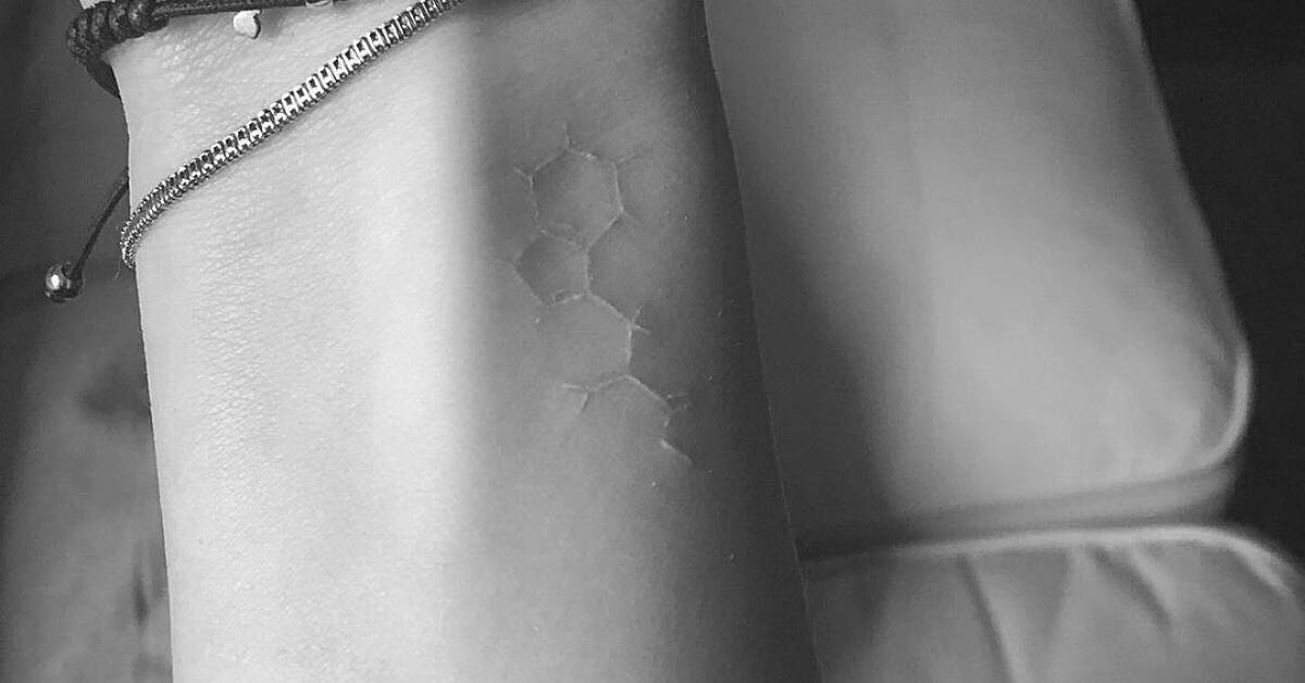 White ink chemical structure tattoo on the inner wrist.
