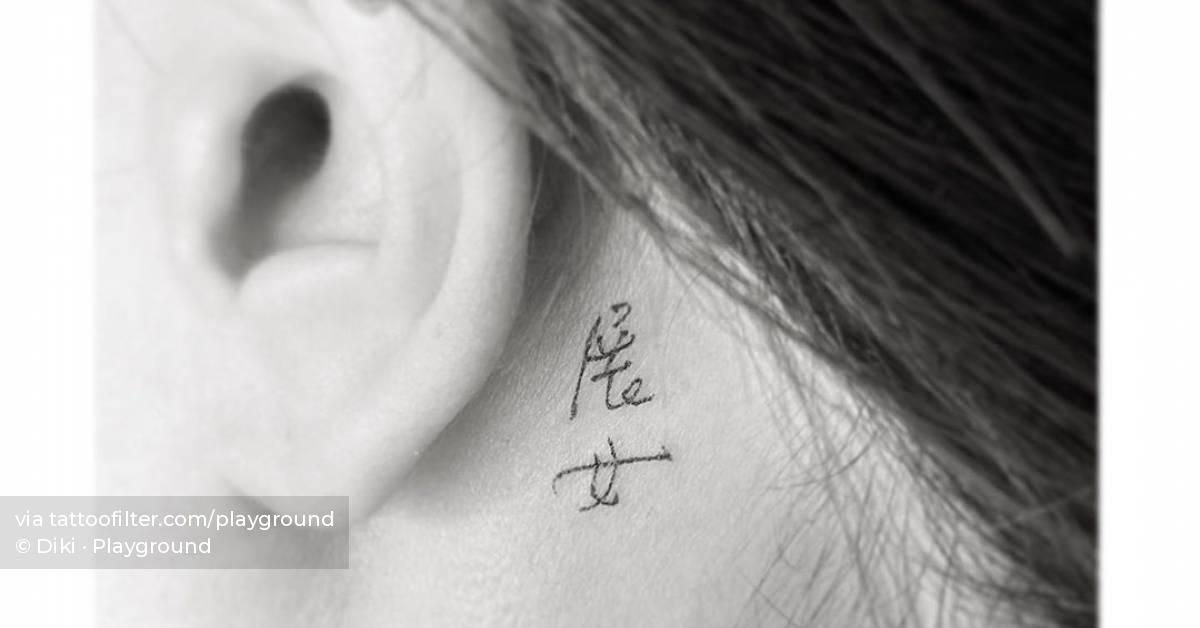 Lettering tattoo behind ear