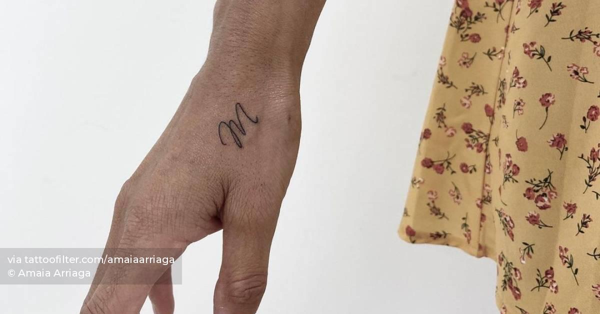 "M" letter tattooed on the hand