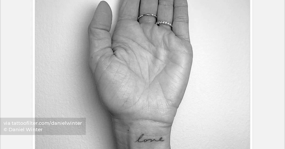"Love" lettering tattoo on the wrist