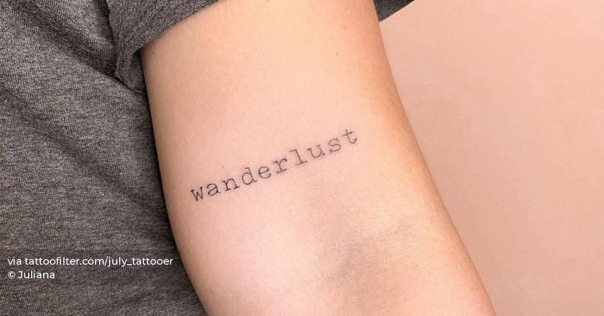 "Wanderlust" lettering tattoo on the bicep
