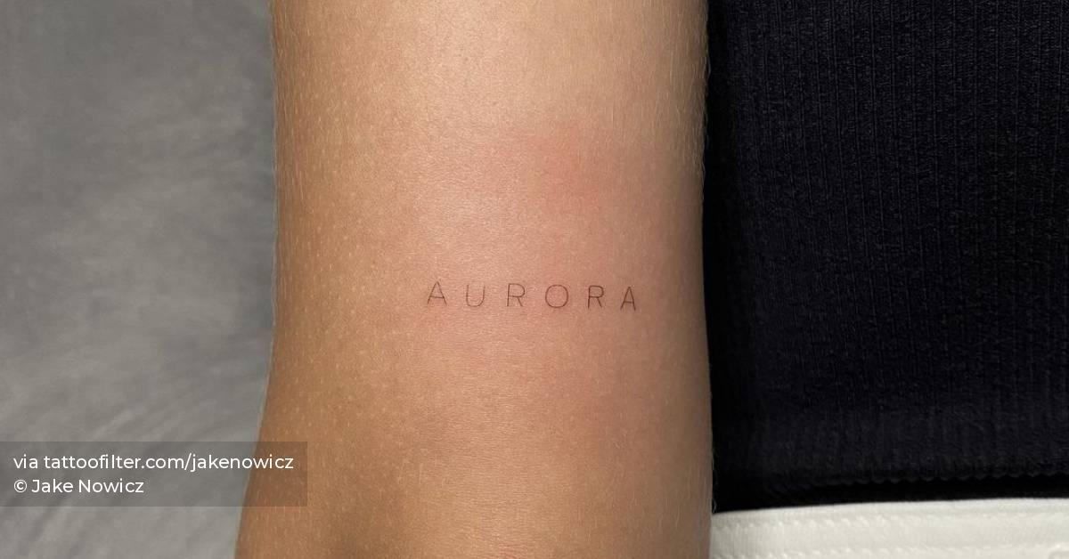 Single needle "Aurora" lettering tattoo on the tricep
