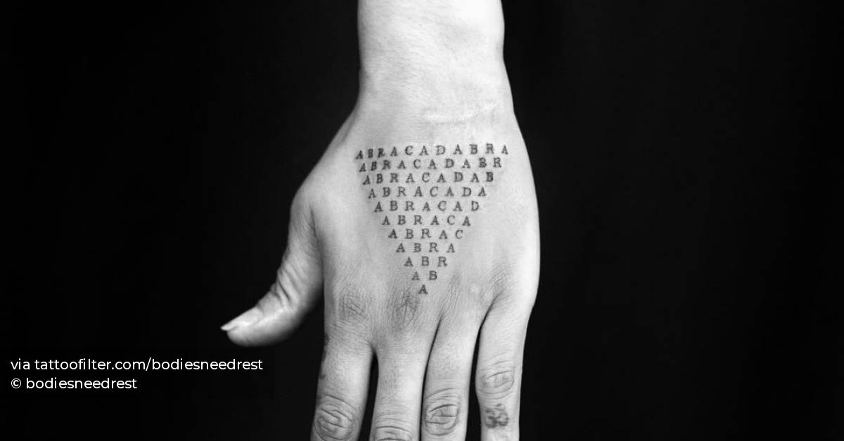 "ABRACADABRA" lettering tattoo in the shape of a