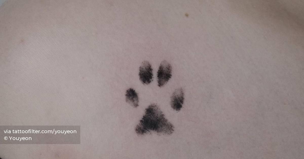 Watercolor dog paw print tattoo on the chest