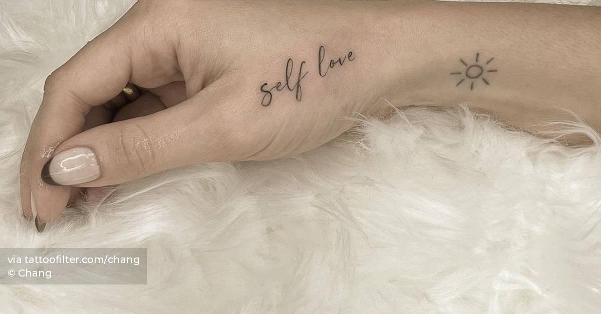 "self love" lettering tattoo on the hand