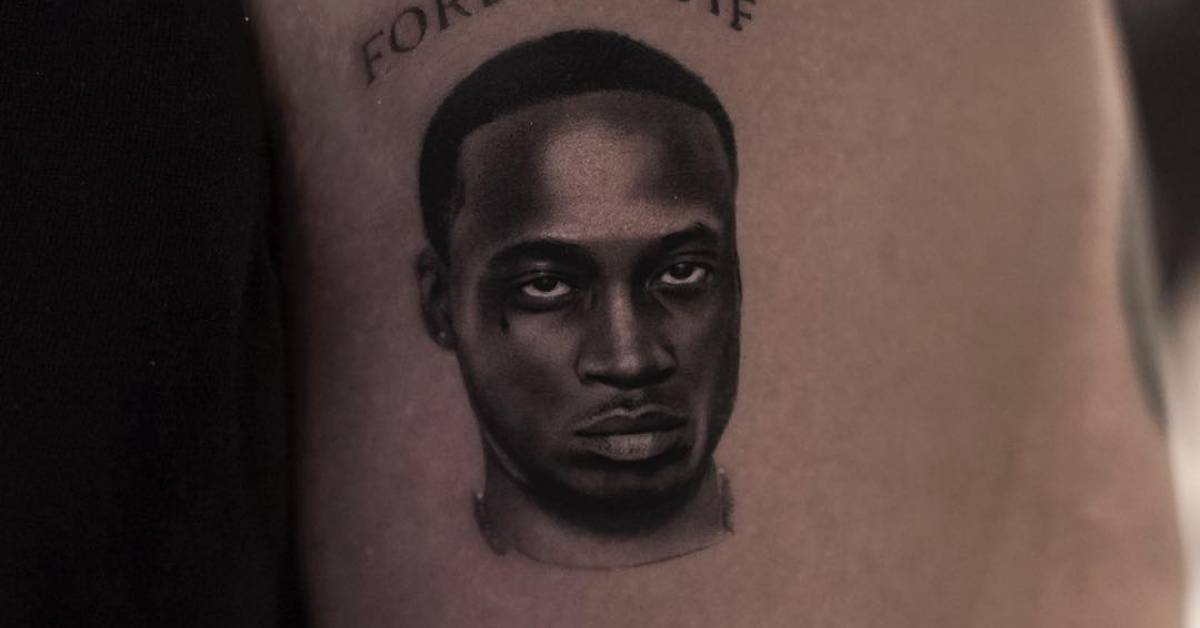 Black and grey tattoo of a portrait of Drake’s late