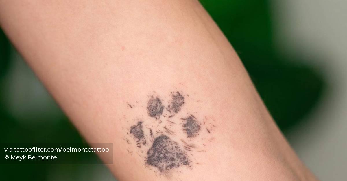 Watercolor dog paw tattoo on the inner arm