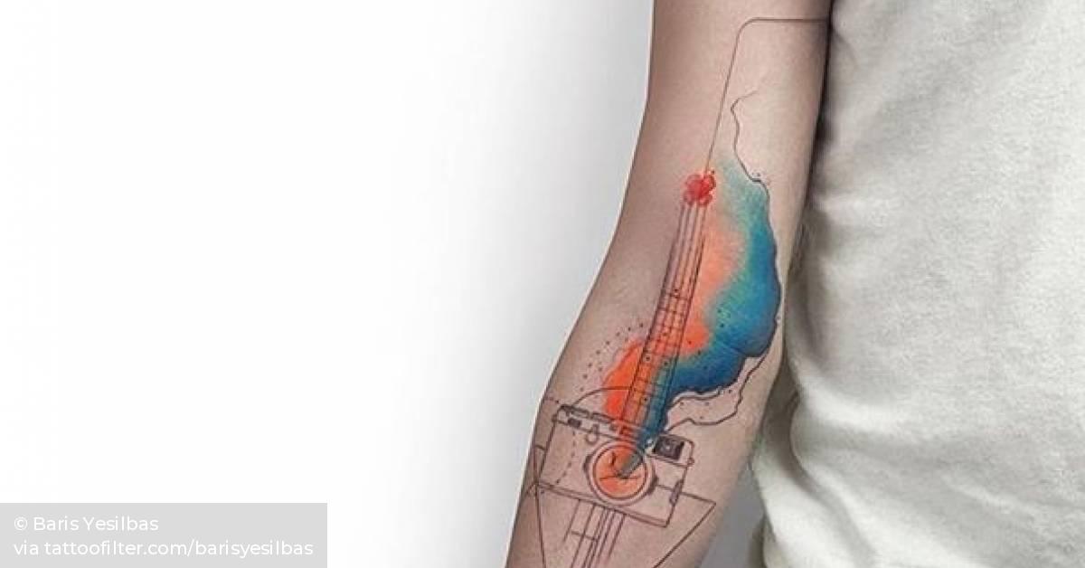 Graphic style photo camera tattoo on the right arm.