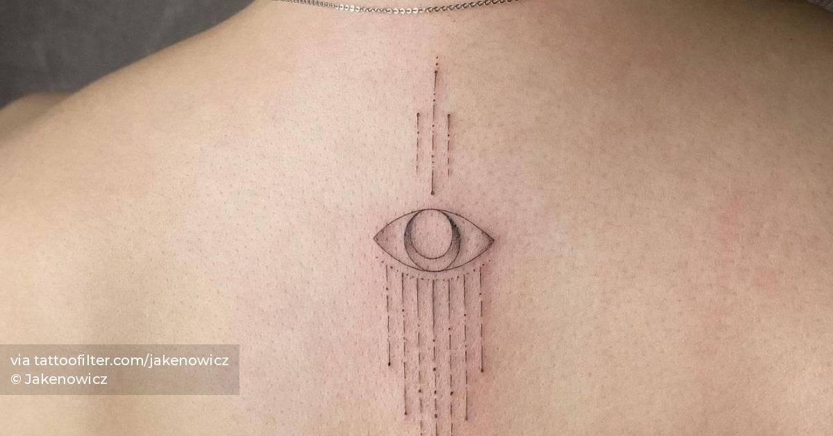 Fine line ornamental eye tattoo on the upper back