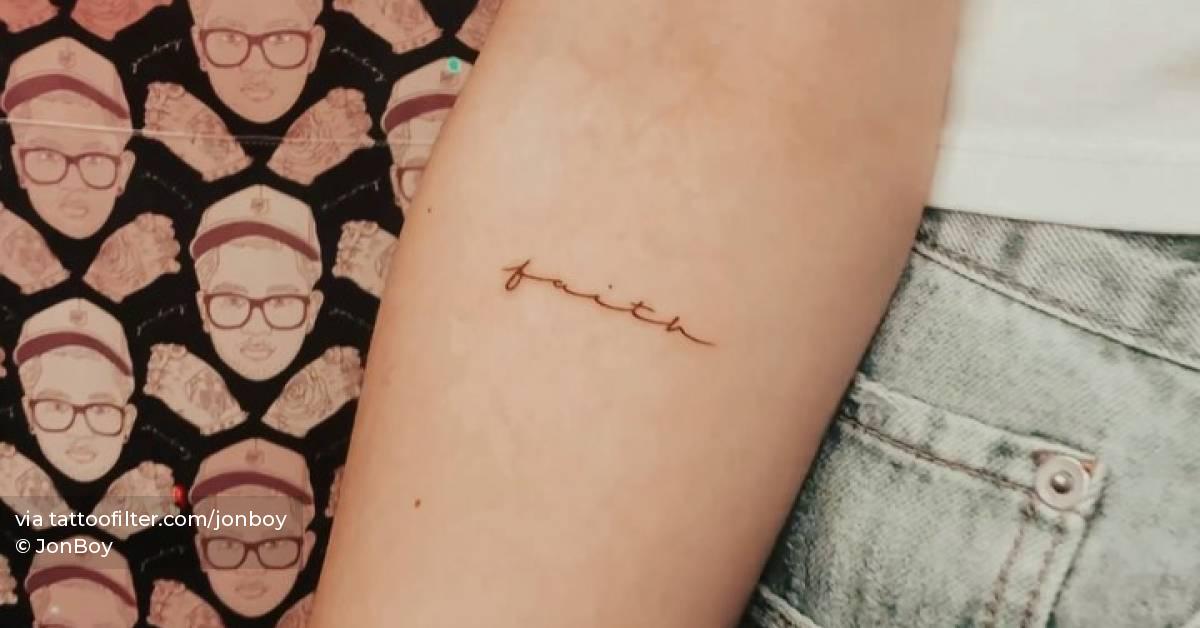 "Faith" lettering tattoo on the inner forearm