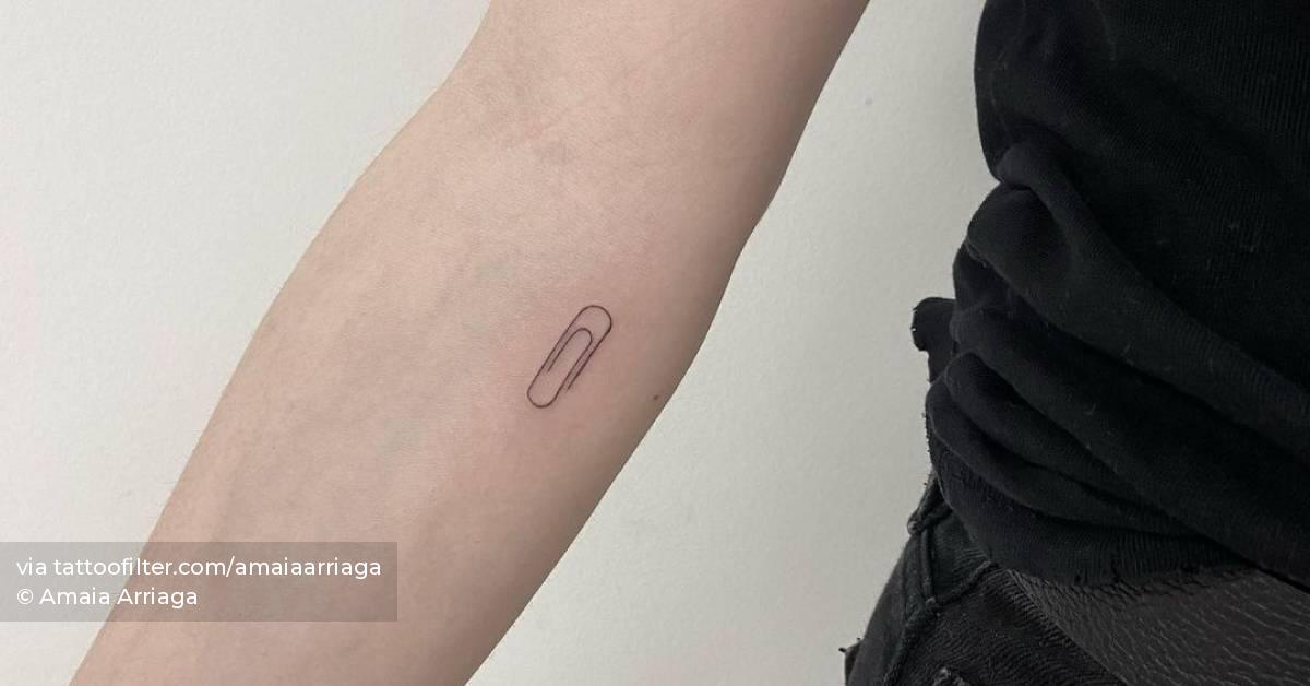 Minimalist paper clip tattoo on the inner forearm