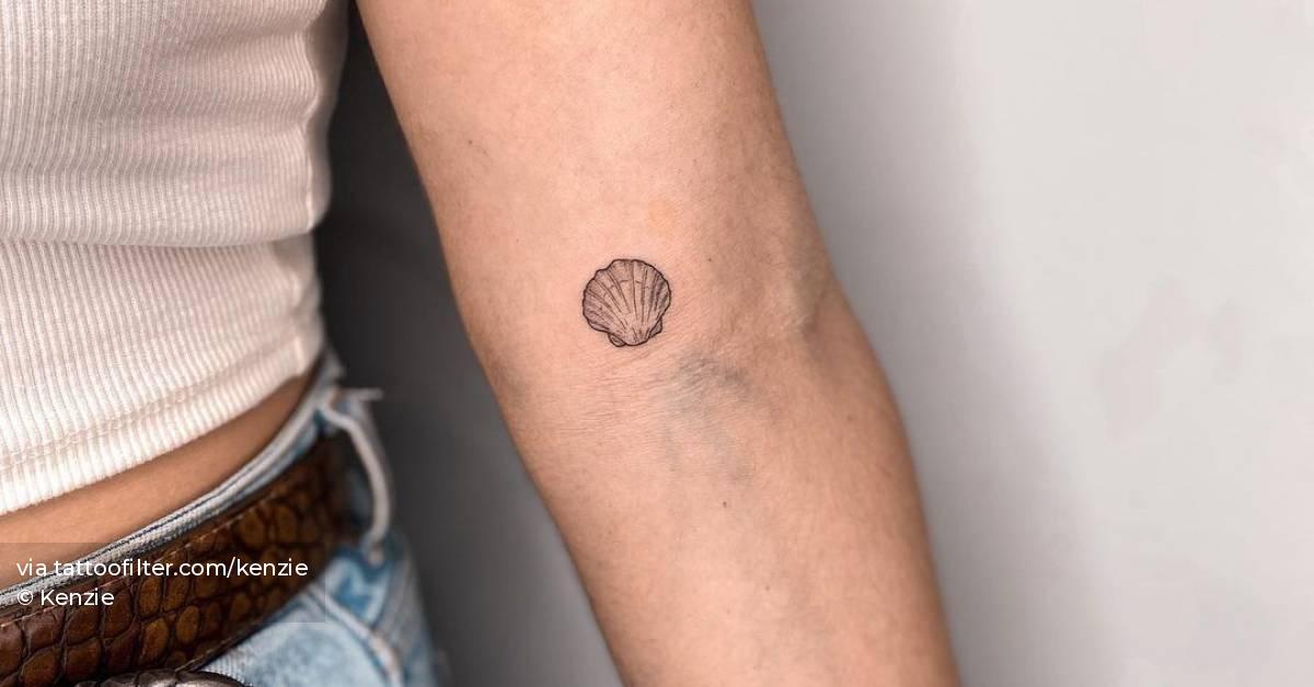 Fine line shell tattoo on the bicep