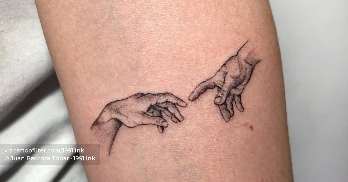 Hands from "The Creation of Adam" tattooed on the inner