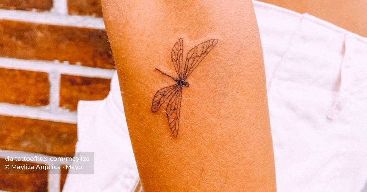 Fine line dragonfly tattoo on the forearm