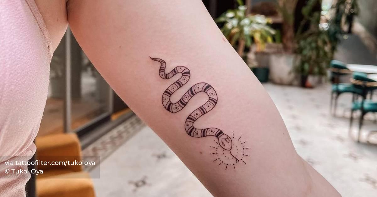 Ornamental snake tattoo on the inner arm