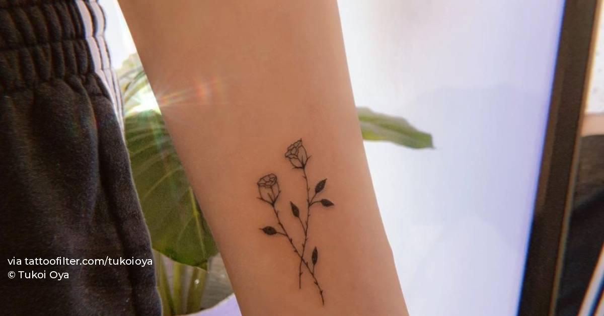 Fine line roses tattooed on the inner forearm