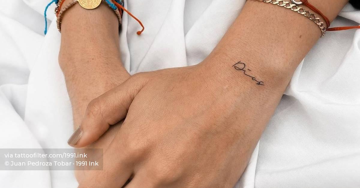 "Dios" lettering tattoo on the wrist