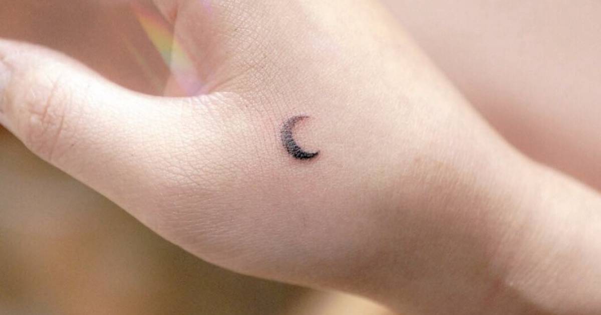 Minimalist crescent moon tattoo on the hand