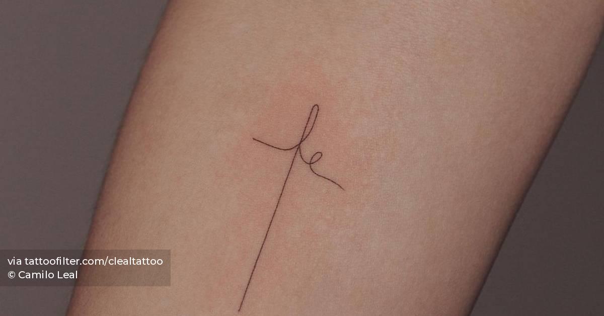 "Fe" lettering tattoo on the inner forearm