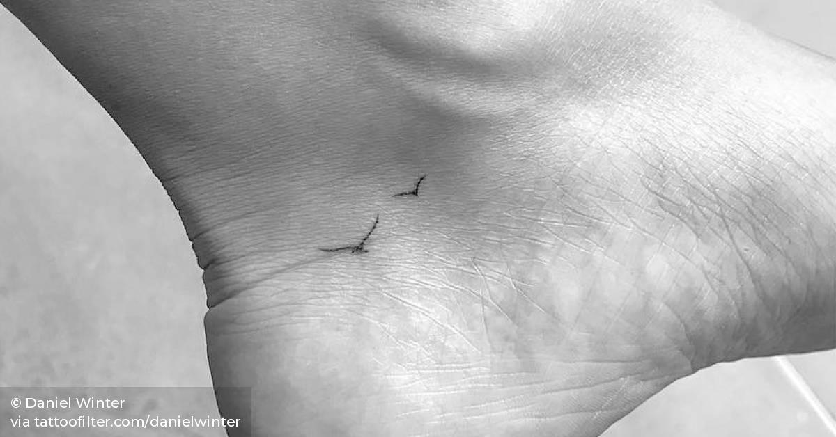 Two flying birds on the ankle.