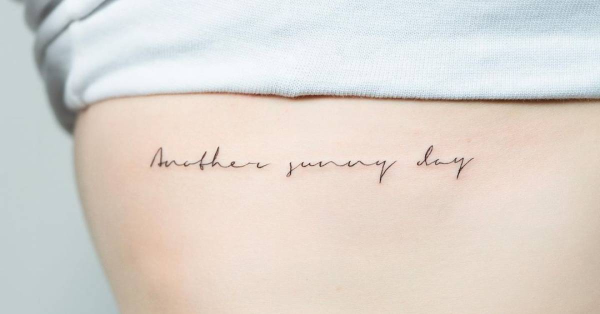 "Another sunny day" lettering tattoo on the rib