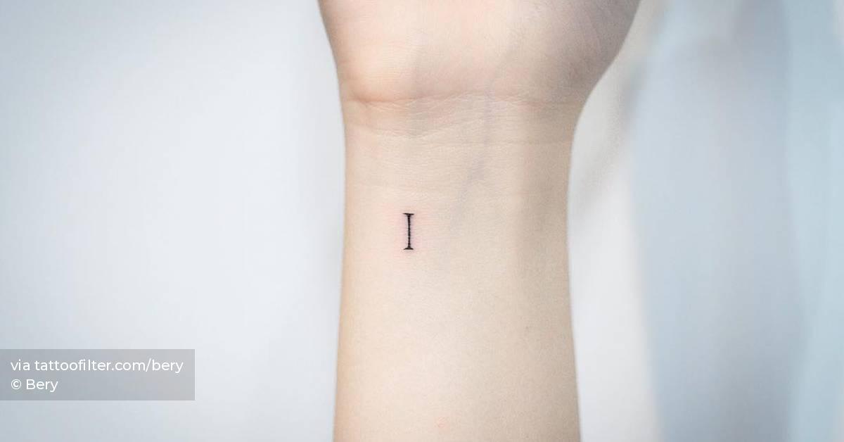 Minimalist "I" tattoo on the wrist.