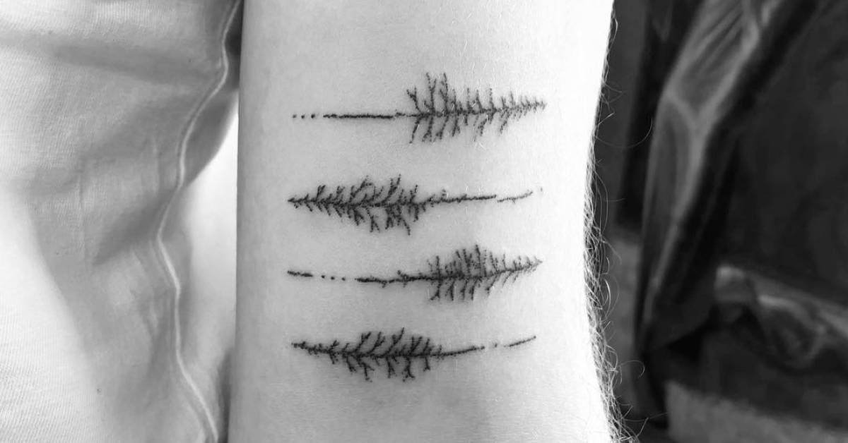 Hand poked pine trees tattooed on the bicep.
