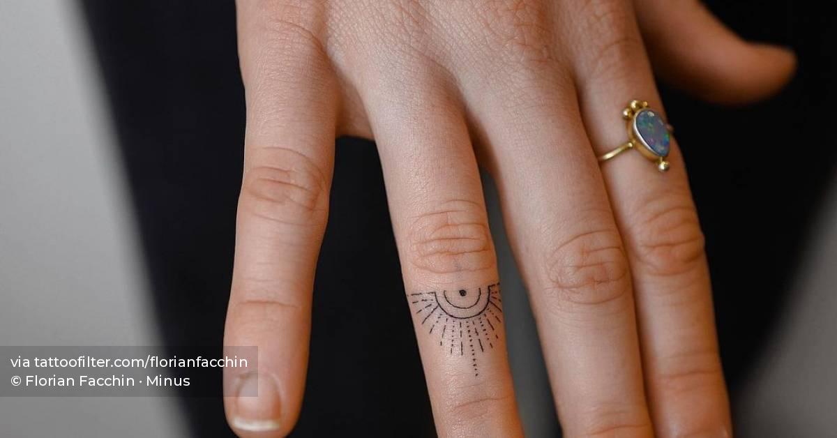 Fine line sun tattoo on the finger.