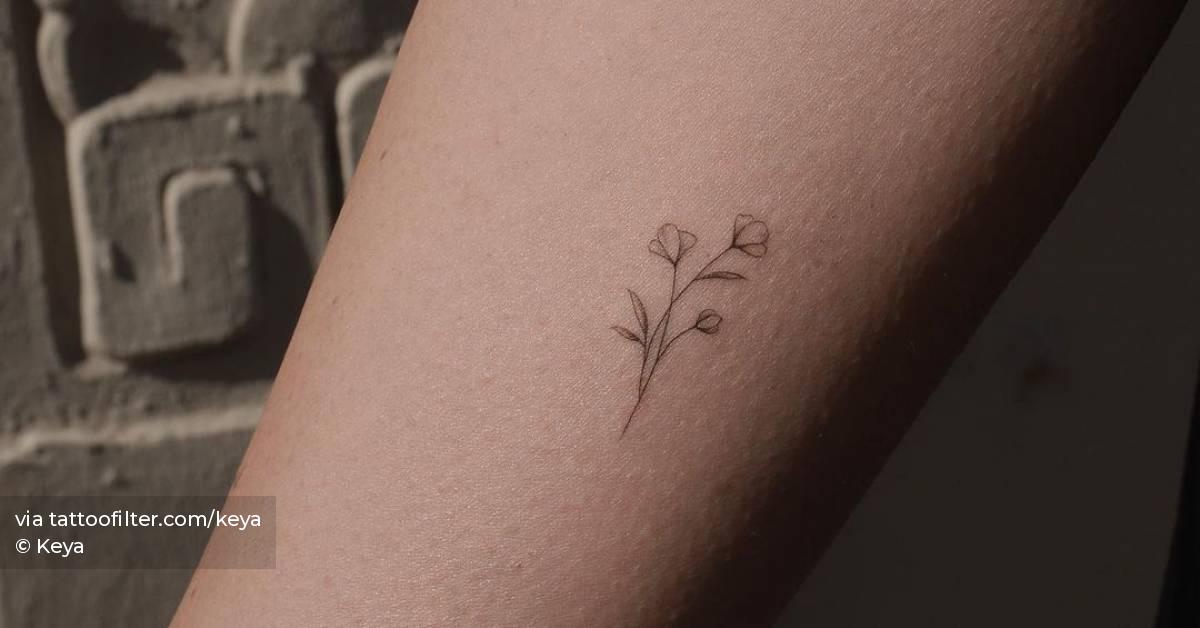 Fine line flower tattoo on the inner forearm.