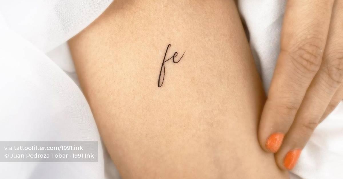 "Fe" lettering tattoo on the inner forearm.