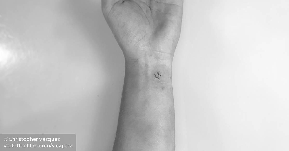 Minimalist star tattoo on the wrist.