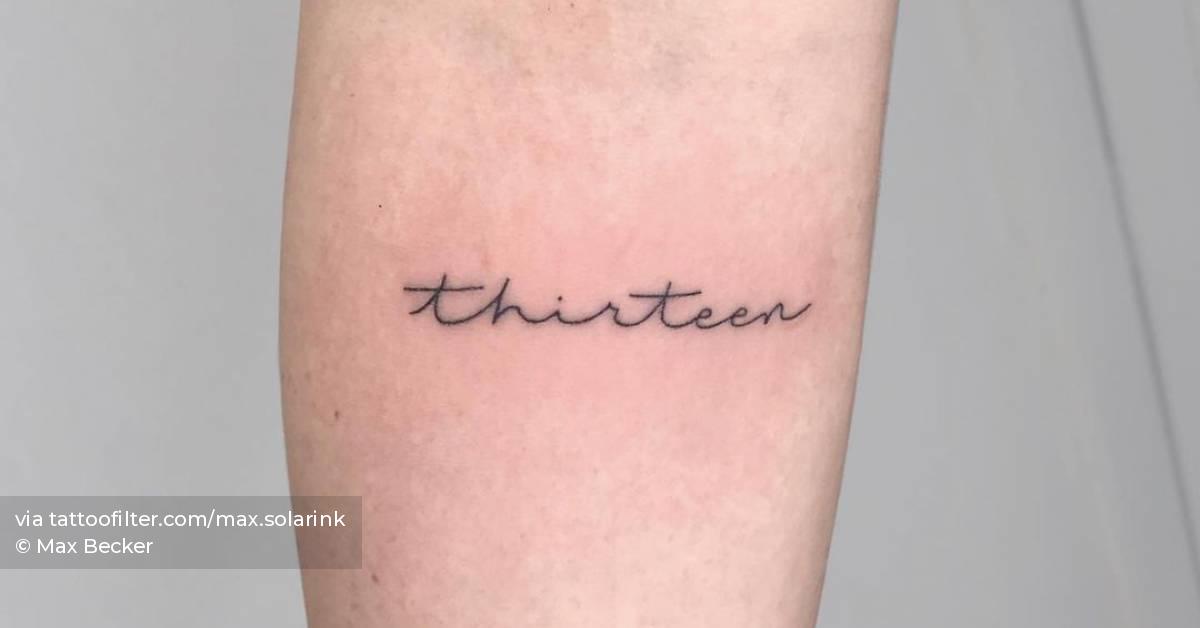 "Thirteen" lettering tattoo on the inner forearm.