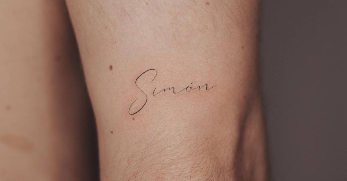"Simon" lettering tattoo on the tricep.