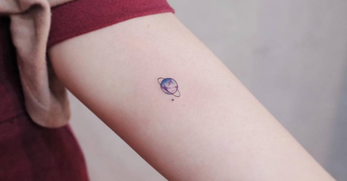 Saturn tattoo on the left inner forearm.