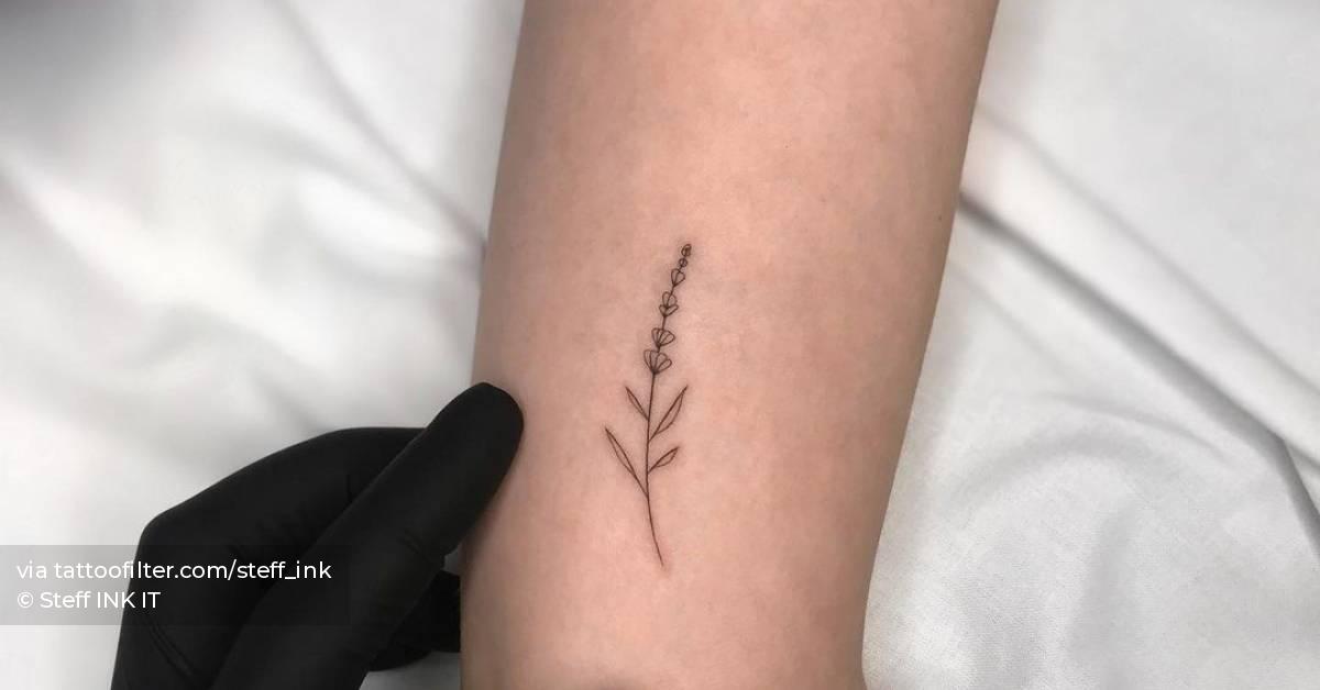 Fine line lavender tattoo on the inner arm.