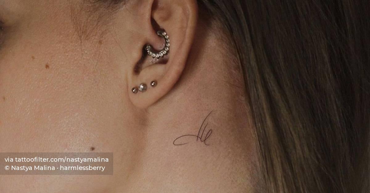Lettering tattoo behind the ear.