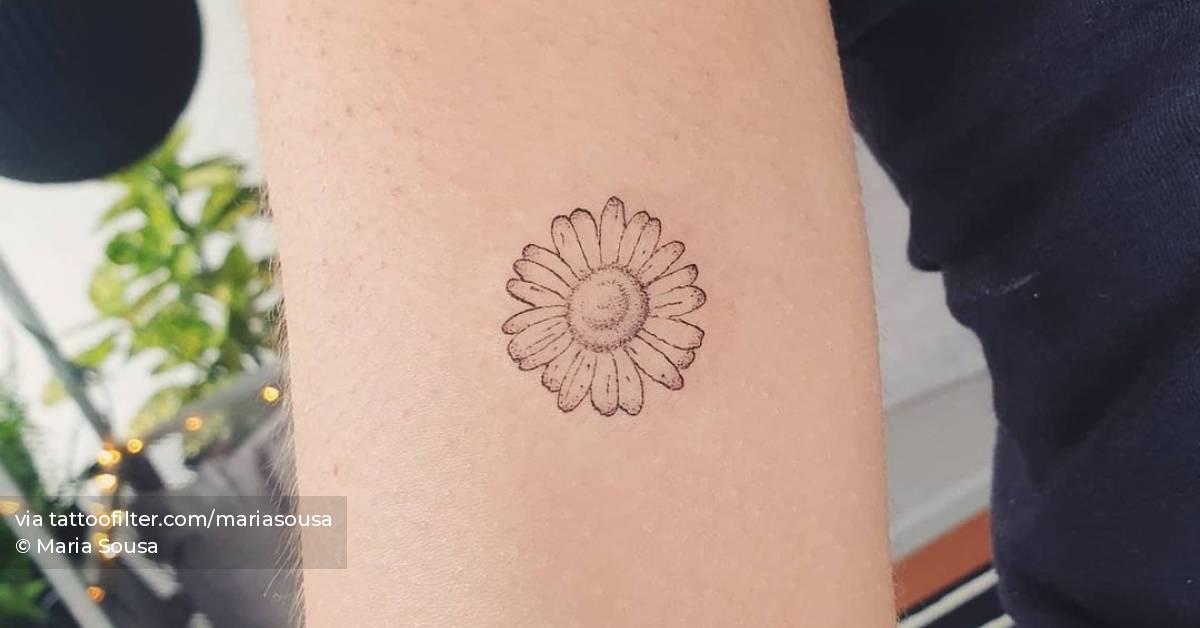 Fine line daisy tattoo on the bicep.