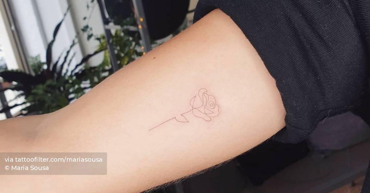 Minimalist one line rose tattoo on the inner arm.