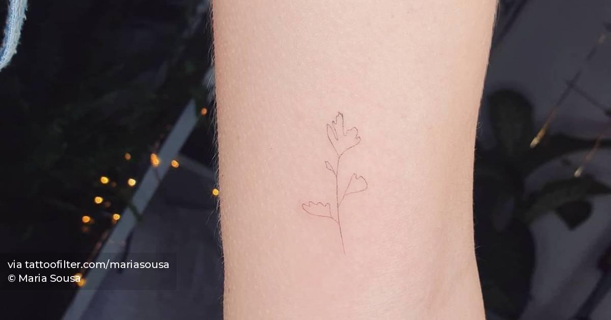Minimalist flower tattoo on the inner arm.