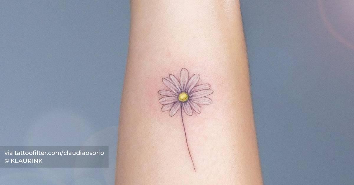 Fine line daisy tattoo on the forearm.