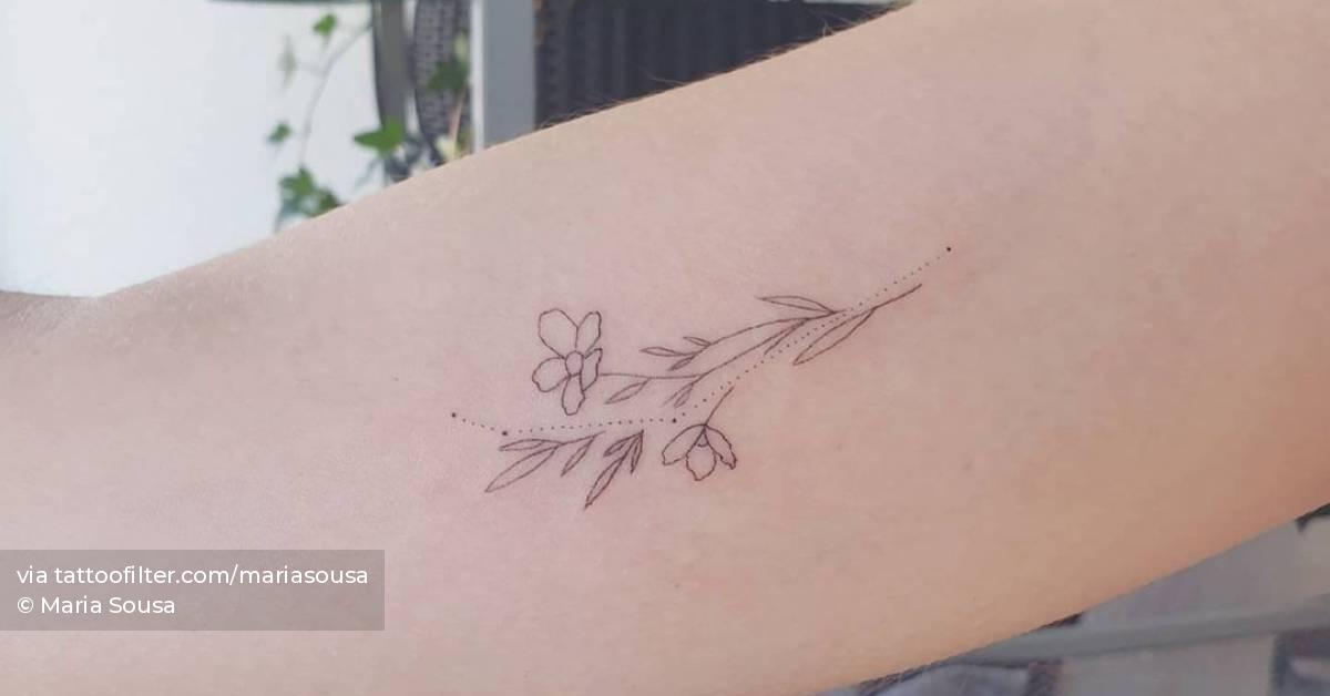 Fine line flower tattoo on the inner arm.