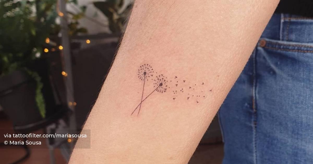Fine line dandelion seed tattoo on the inner forearm.